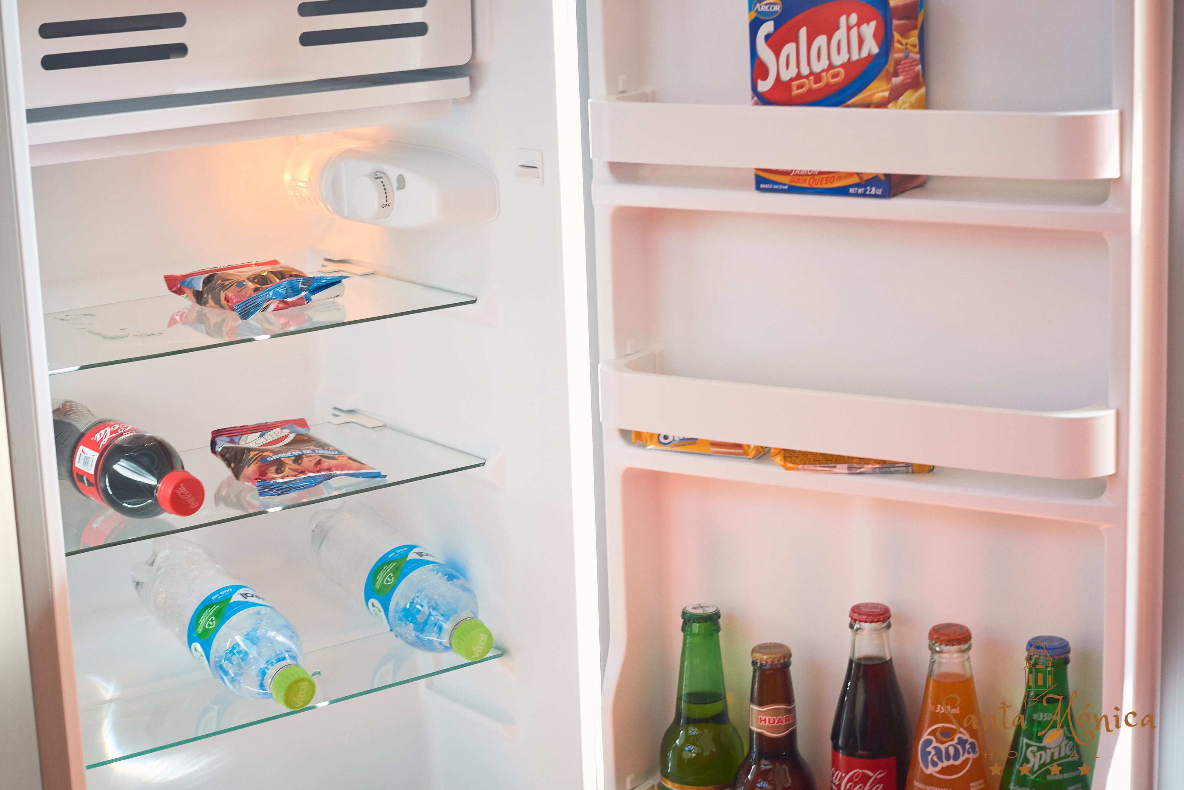 Uma geladeira com prateleiras contendo diversas bebidas e uma caixa de Saladix Duo.