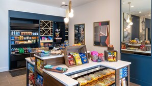 Um bar de lanches com diversos alimentos e bebidas, incluindo batatas fritas, biscoitos e refrigerantes.