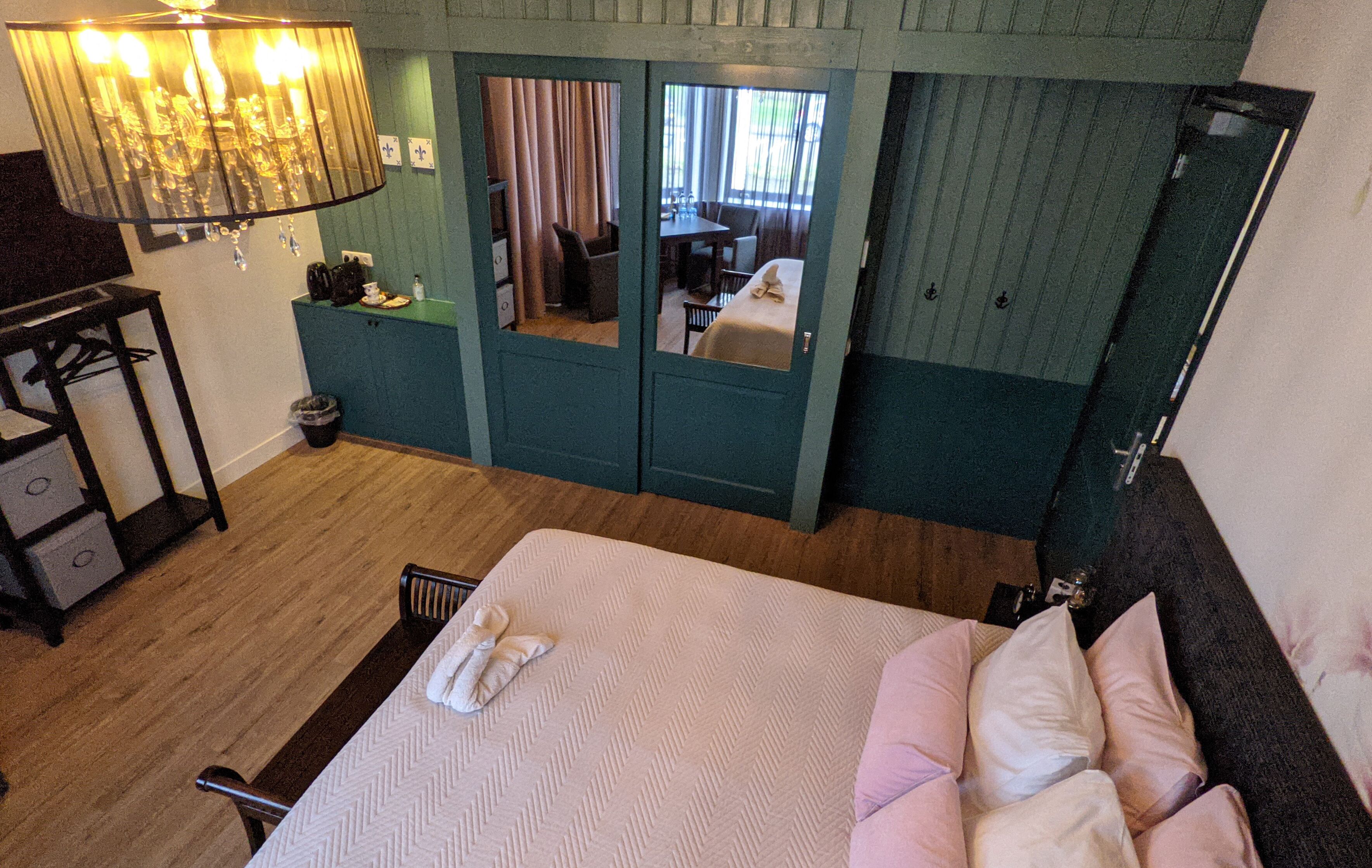 Quarto com cama, mesa de cabeceira e espelho.