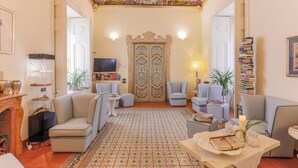 Uma sala de estar com um tapete estampado, dois sofás, uma mesa de centro e uma lareira.