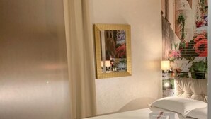 Quarto de hotel com cama, espelho e um quadro na parede.