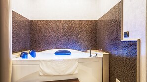 Um banheiro moderno com uma banheira livre, um espelho grande e um painel de azulejos.