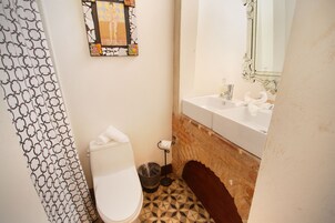 Casa de banho com sanita, lavatório e banheira.