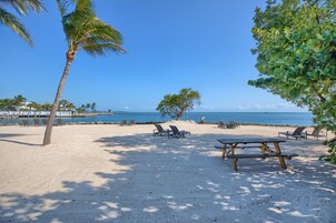 Uma praia privada, espreguiçadeiras, toalhas de praia, caiaque 