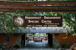 Placa do Centro de Espécies Ameaçadas de Hoedspruit, com endereço de site e slogan.