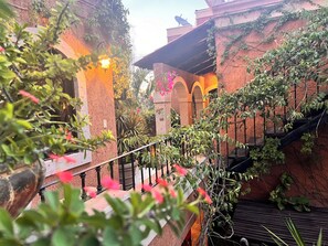 Um pátio com escadas, paredes de tijolo e vegetação.
