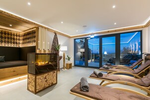 Uma sala de estar moderna com lareira, poltronas confortáveis e uma grande porta de vidro que dá para uma área externa.