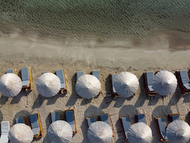 Praia particular, espreguiçadeiras, guarda-sóis, toalhas de praia