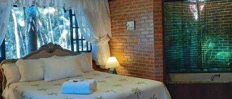 Um quarto com cama, janela com cortinas, parede de tijolos e mesa de cabeceira com abajur.