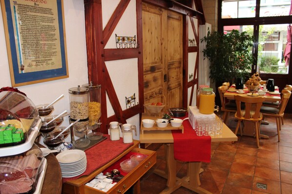 Um buffet de café da manhã com diversos alimentos e utensílios.