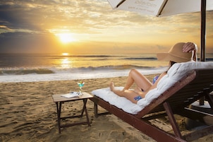 Na praia, praia de areia branca, espreguiçadeiras, guarda-sóis de praia 