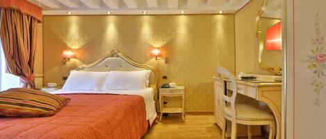 Quarto de hotel com uma cama grande, luminárias de cabeceira, uma escrivaninha e uma cadeira.