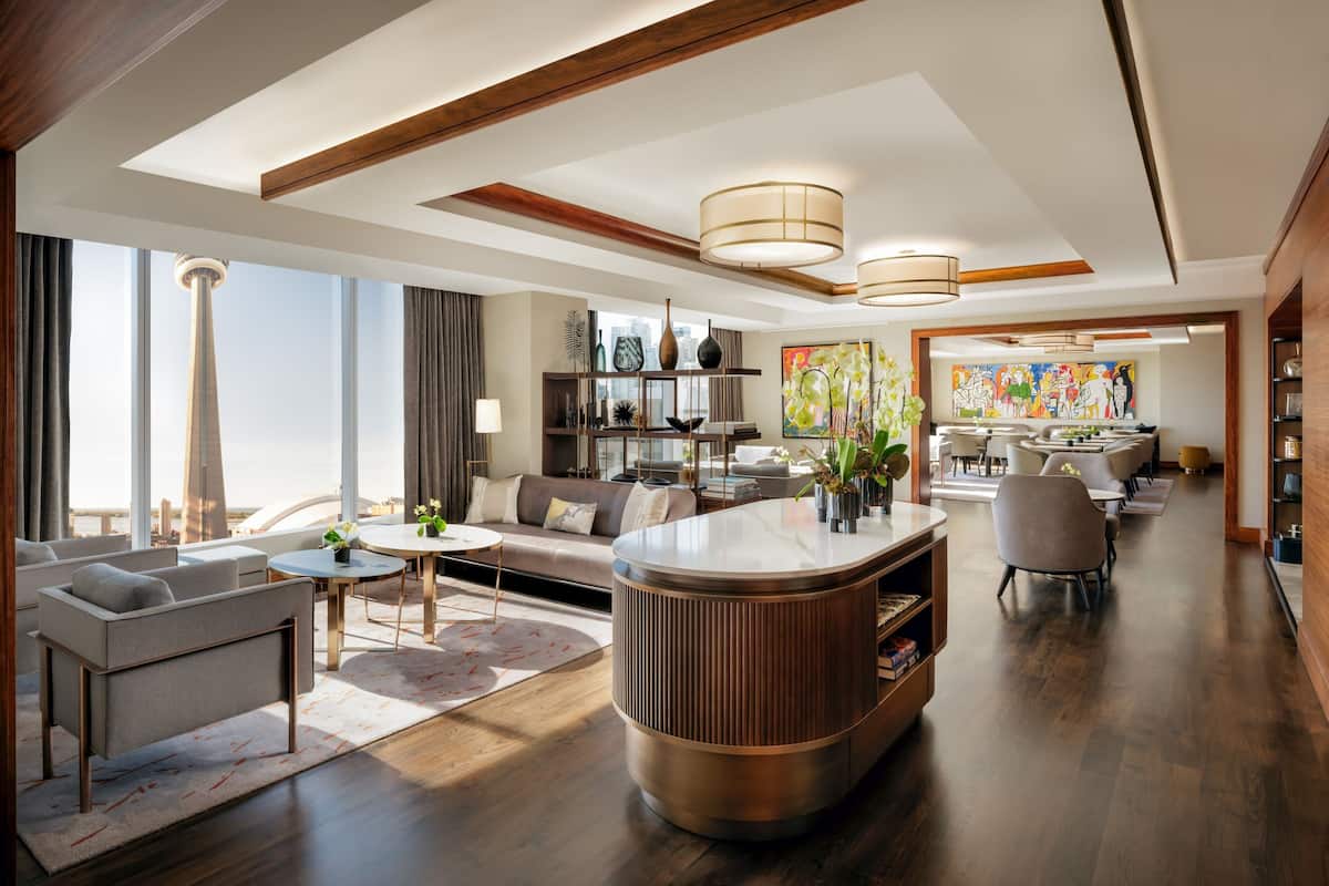 Ampla sala de estar com design moderno, destacando uma mesa de centro, sofás e um elemento decorativo de madeira exclusivo.