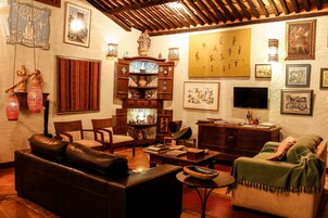 Uma sala de estar acolhedora com lareira, móveis de madeira e diversas decorações nas paredes.