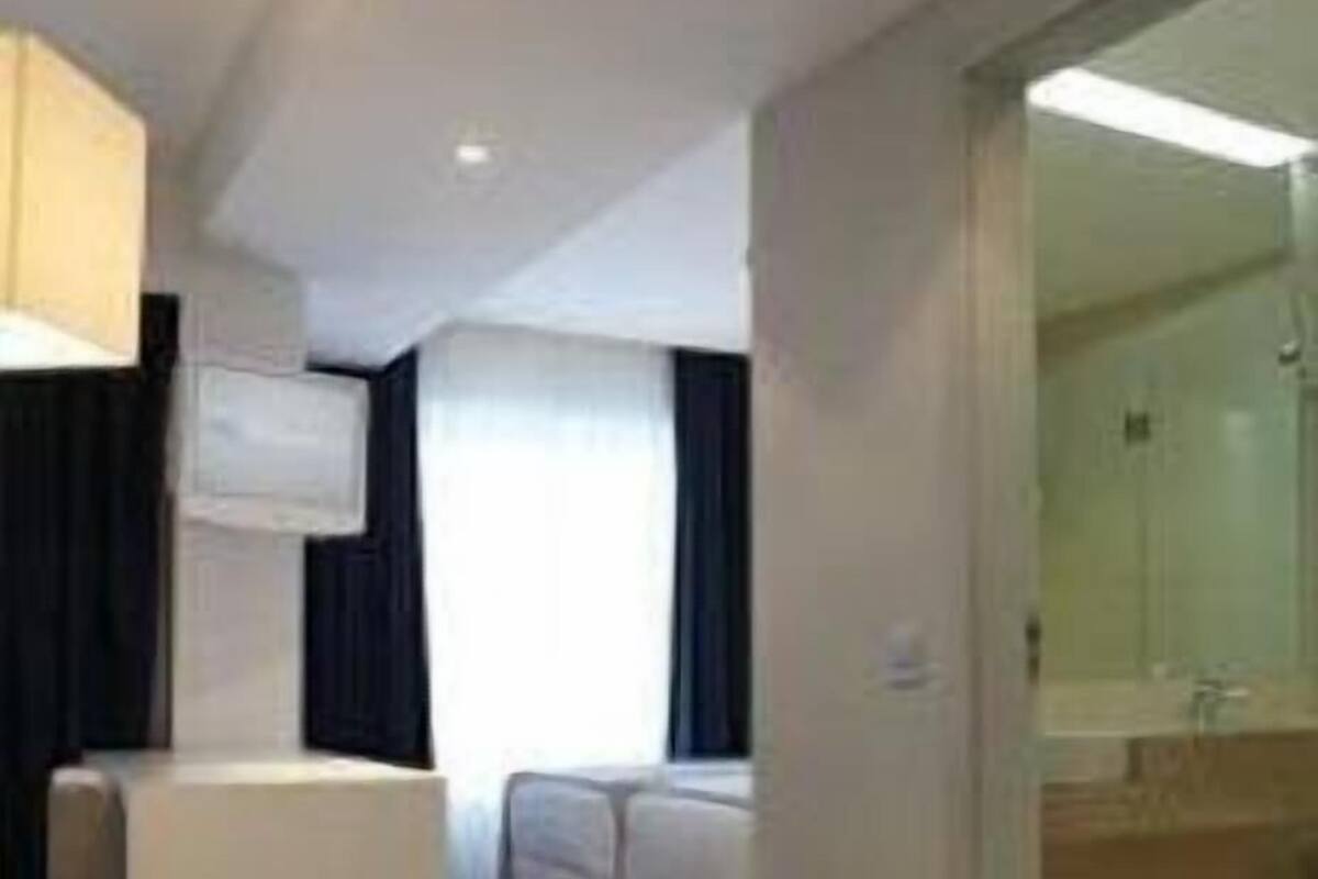 Quarto de hotel com cama, escrivaninha, cadeira, sofá e banheiro.