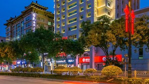 Um hotel com vários andares e estilo arquitetônico tradicional, destacando uma entrada imponente com cobertura e colunas.