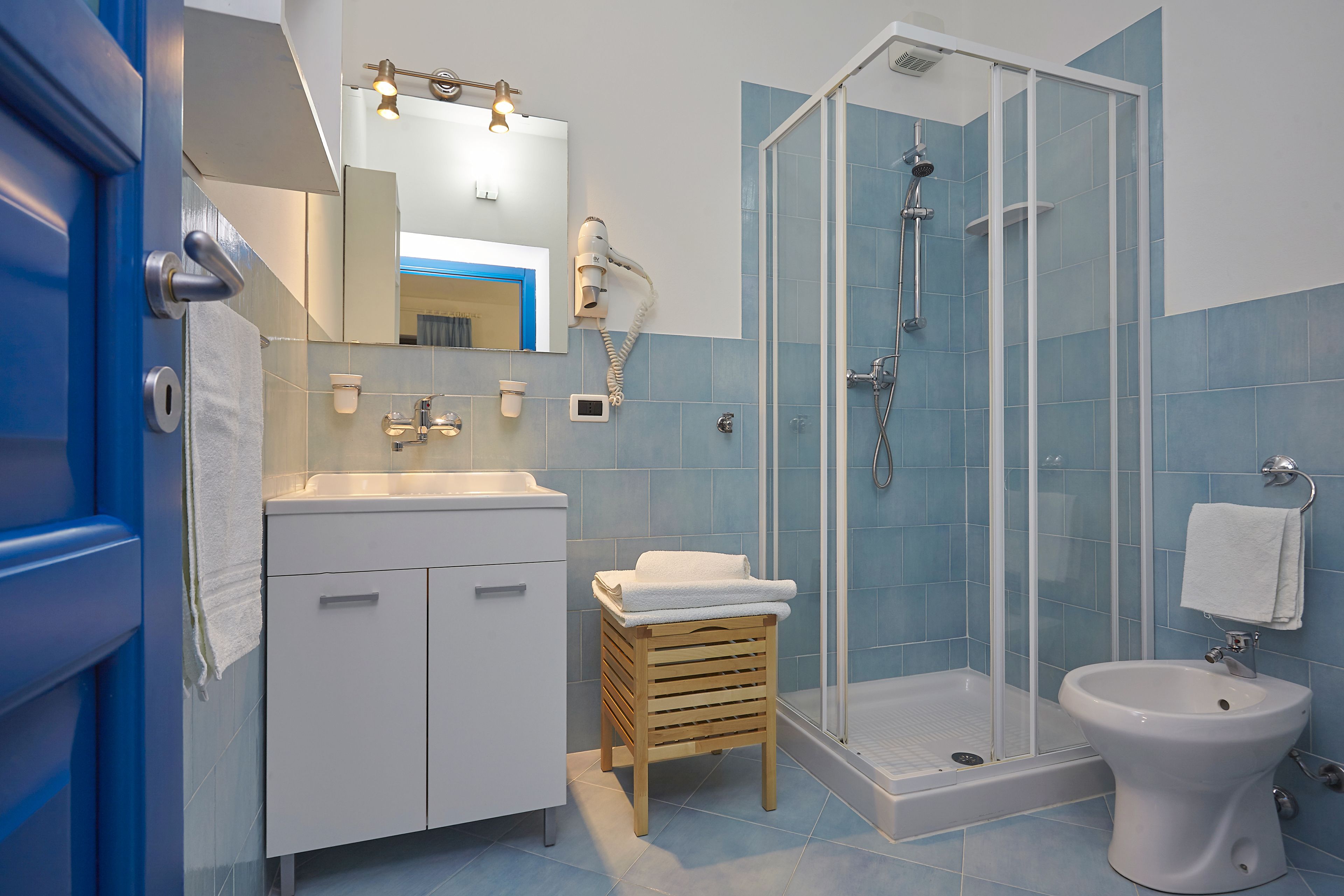 Uma casa de banho moderna com chuveiro, sanita e lavatório.