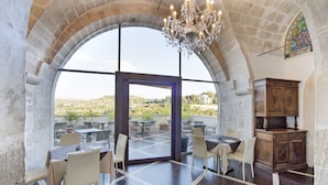 Uma sala de jantar ampla com vista para a paisagem, um candelabro e um armário de madeira.