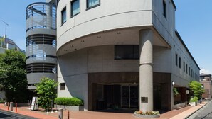 Um edifício moderno com fachada curva, janelas amplas e entrada imponente.