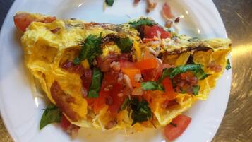 Um prato com omelete, tomate e ervas.
