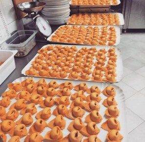 Bandejas com ravioli dispostos cuidadosamente sobre uma mesa em uma cozinha.