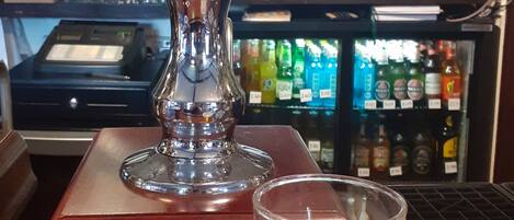 Uma torneira com a inscrição 'Tyneside Blonde' e um copo de cerveja sobre um apoio.