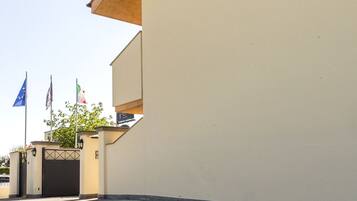 Exterior do Borgo Castel Savelli Residence, com entrada pavimentada e bandeiras.