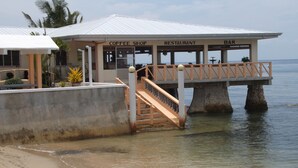Uma construção à beira-mar com cafeteria, restaurante e bar.