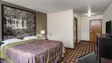 Quarto de hotel com uma cama grande, uma escrivaninha, uma cadeira, uma televisão, um telefone e um quadro de uma cascata.
