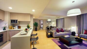 Uma sala de estar moderna com sofá, mesa de centro e área de jantar com cadeiras e mesa.