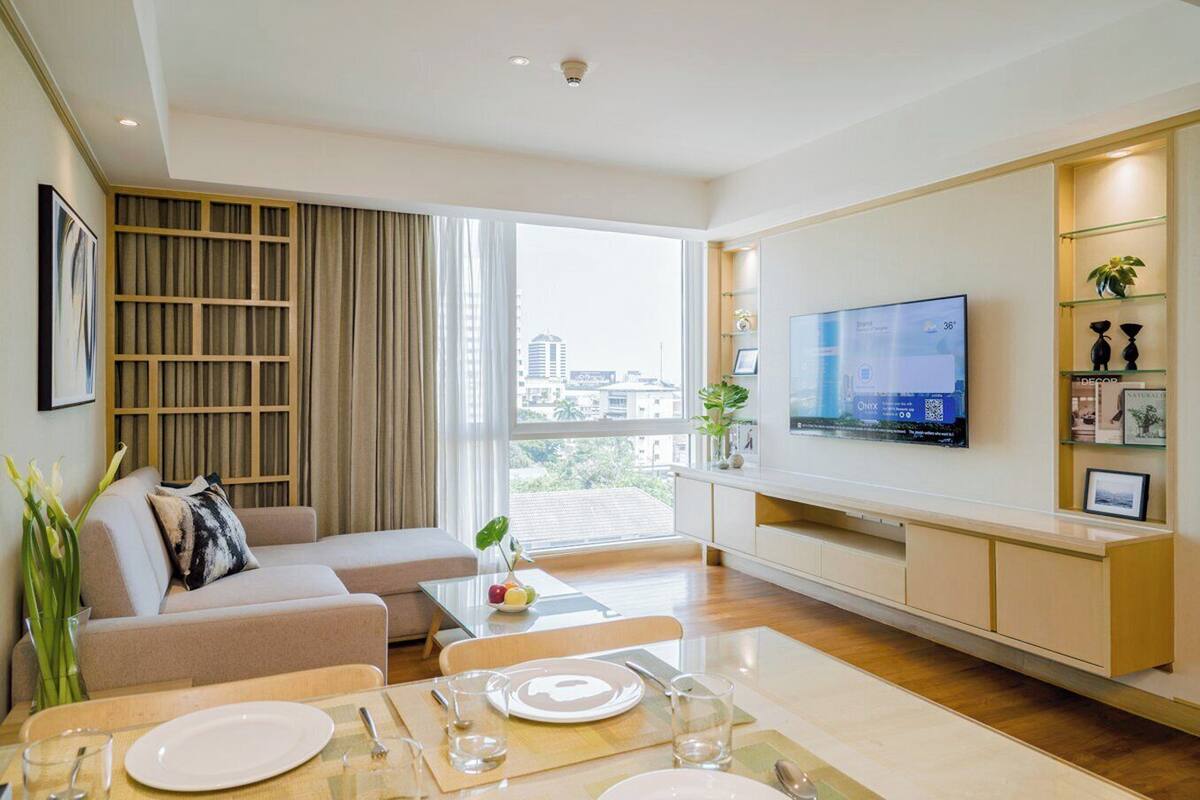 Uma sala de estar moderna com sofá, mesa de jantar e televisão.