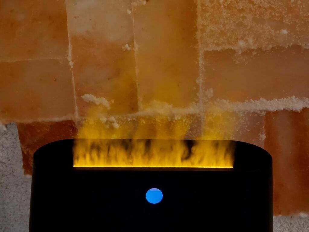 Um objeto preto com uma luz azul no topo, emitindo chamas amarelas.