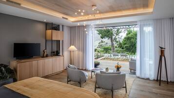 Quarto moderno com uma cama grande, uma televisão, uma escrivaninha e vista para o exterior.