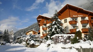 Hotel com várias varandas e paisagem coberta de neve.