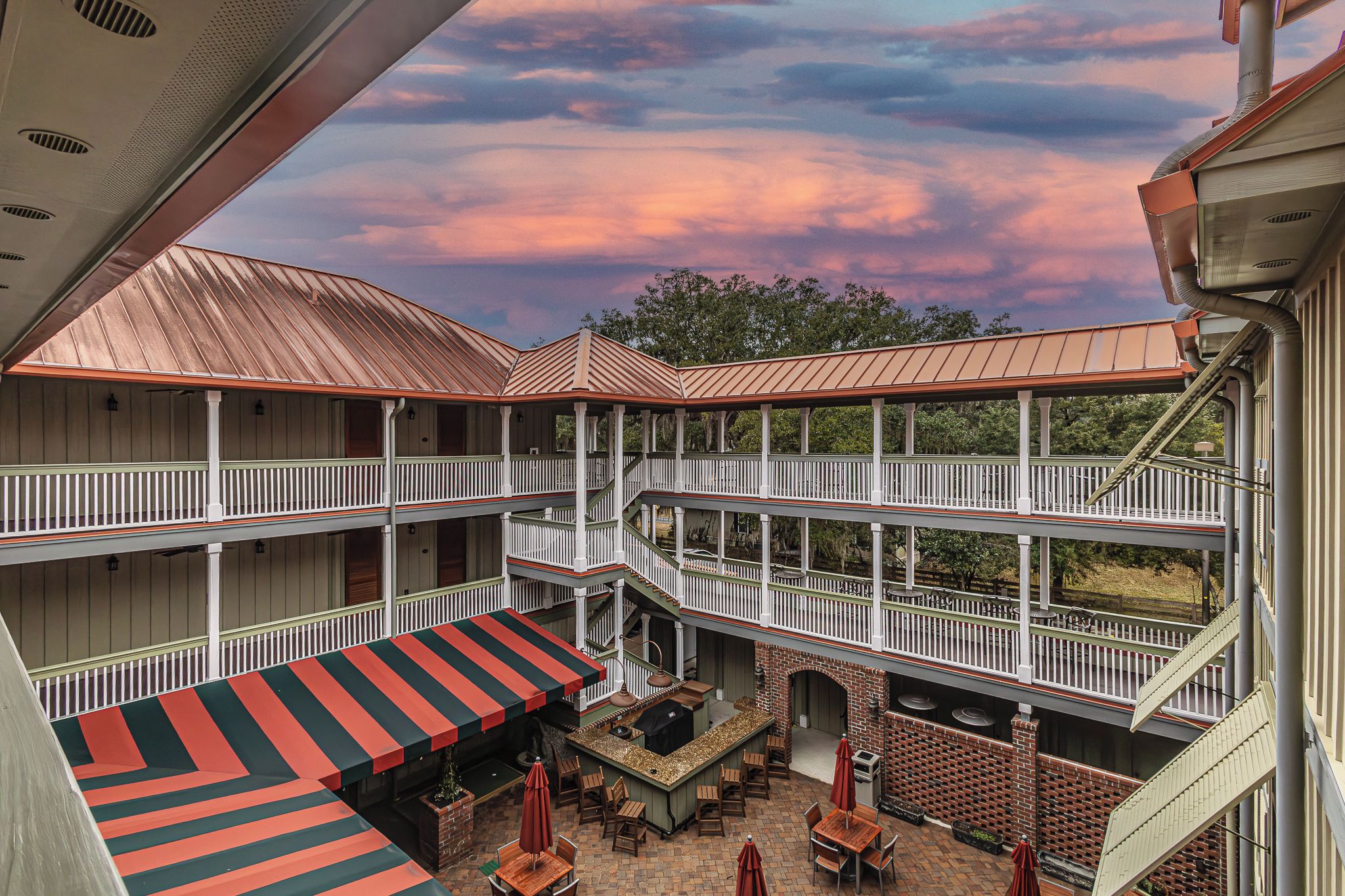 Um terraço ao ar livre com vários níveis, área de churrasco em tijolo, assentos e vista do céu.