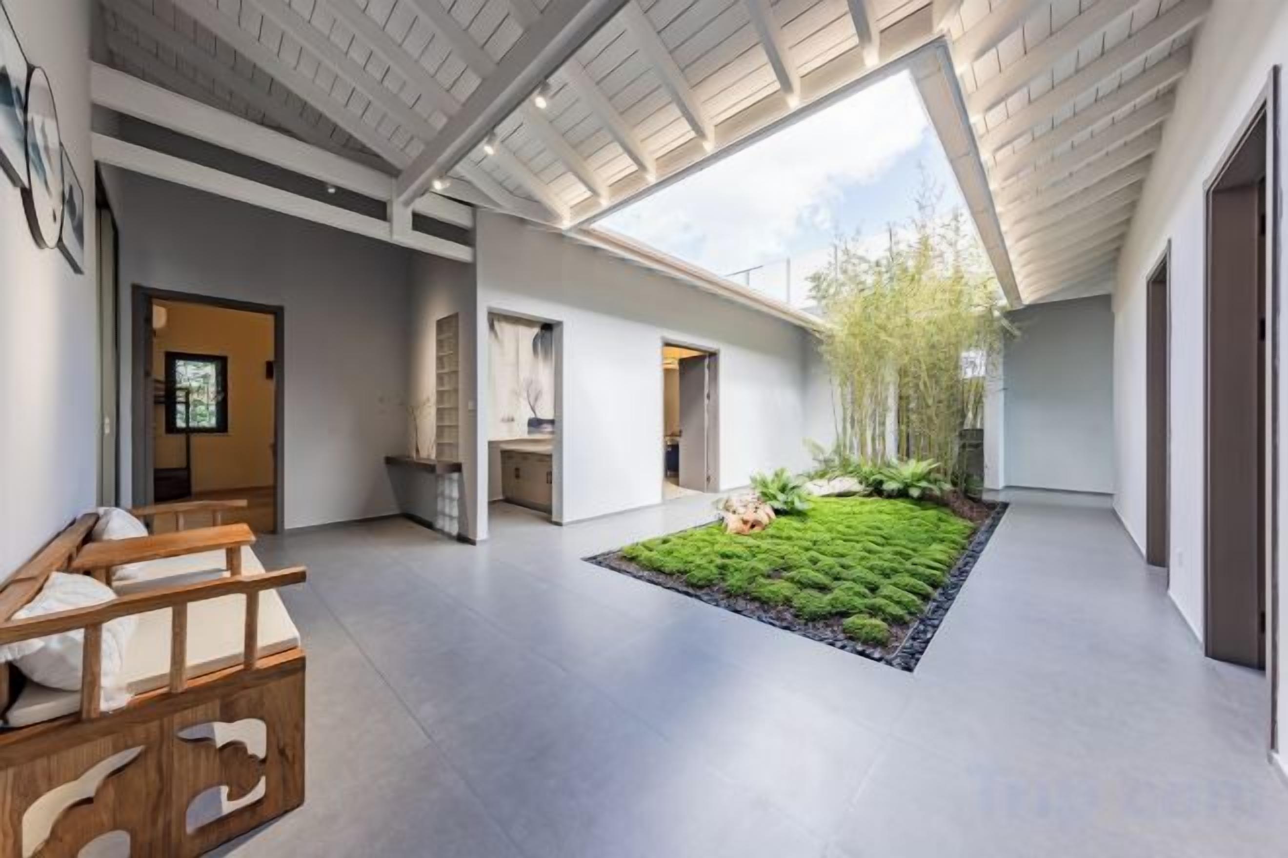 Um interior moderno com telhado plano, um jardim central e área de estar.
