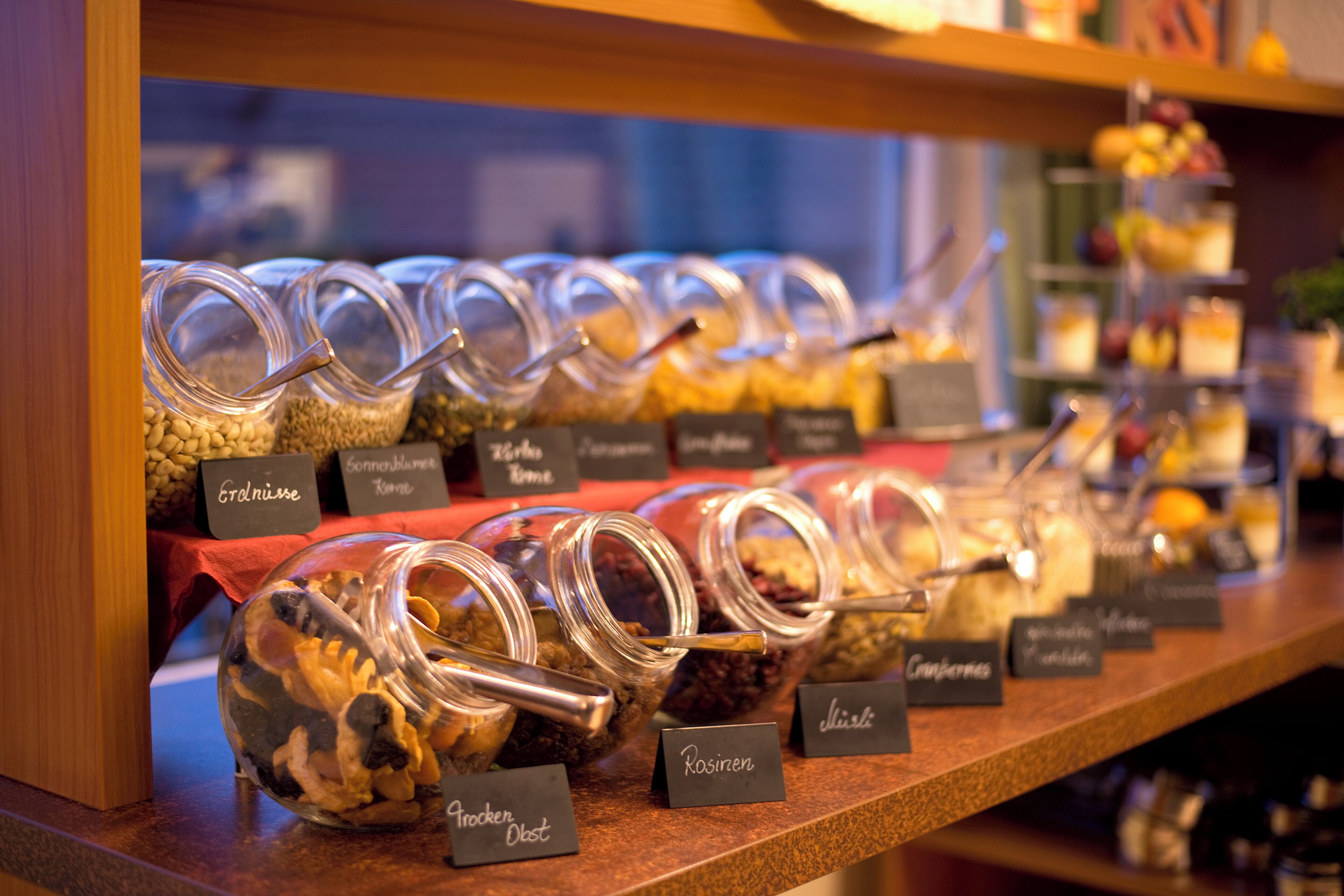 Buffet com recipientes de alimentos identificados.