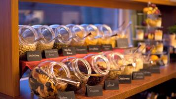 Buffet com recipientes de alimentos identificados.