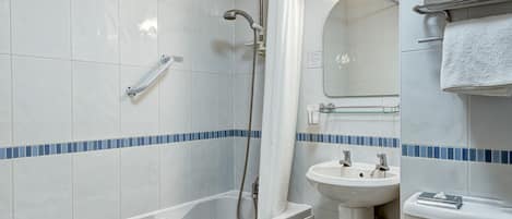 Uma casa de banho com banheira, lavatório e sanita.