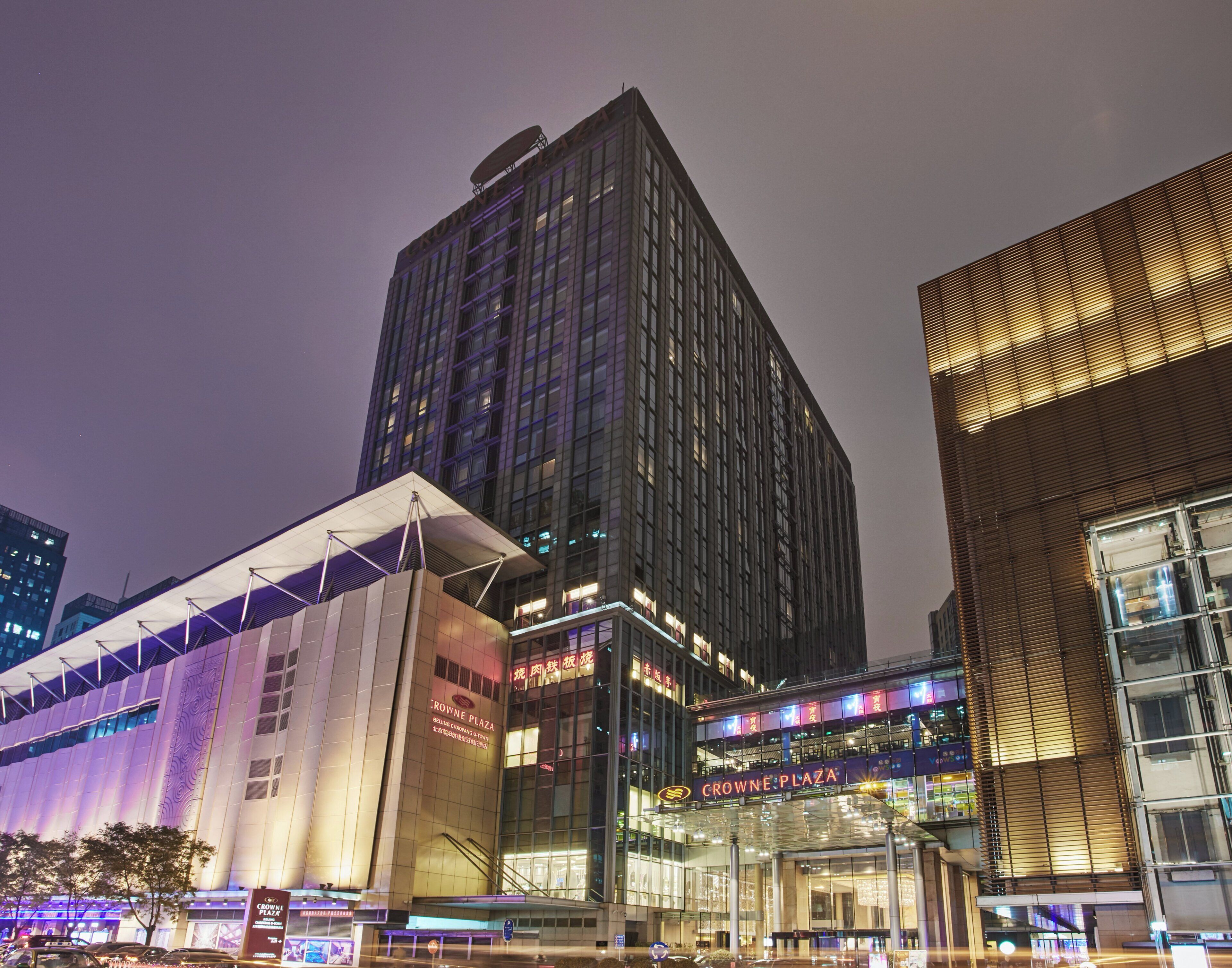 Um edifício com vários andares e uma placa bem visível da Crowne Plaza.