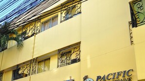 Um edifício amarelo com uma placa que diz