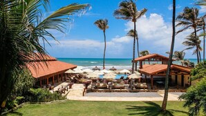 Um resort com área de piscina, espreguiçadeiras e vista para o oceano.