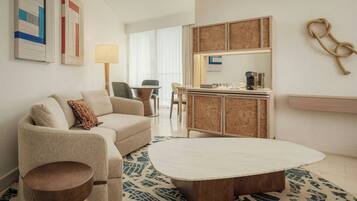 Uma sala de estar moderna com sofá, mesa de centro e um espaço de jantar com cadeiras e mesa.