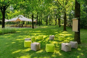 Um parque com mesas de piquenique, um toldo e várias áreas de estar.