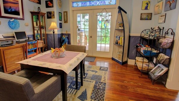Um quarto aconchegante com uma mesa de jantar, cadeiras, uma estante de livros e uma porta com a inscrição 