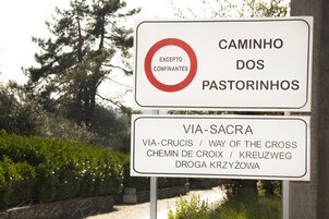 Placa de trânsito bilíngue com as indicações 'Caminho dos Pastorinhos' e 'VIA-SACRA', sinalizando uma rota.