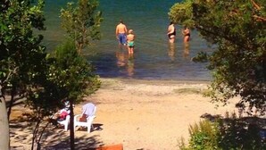 Uma praia com caiaques na água e pessoas nadando.