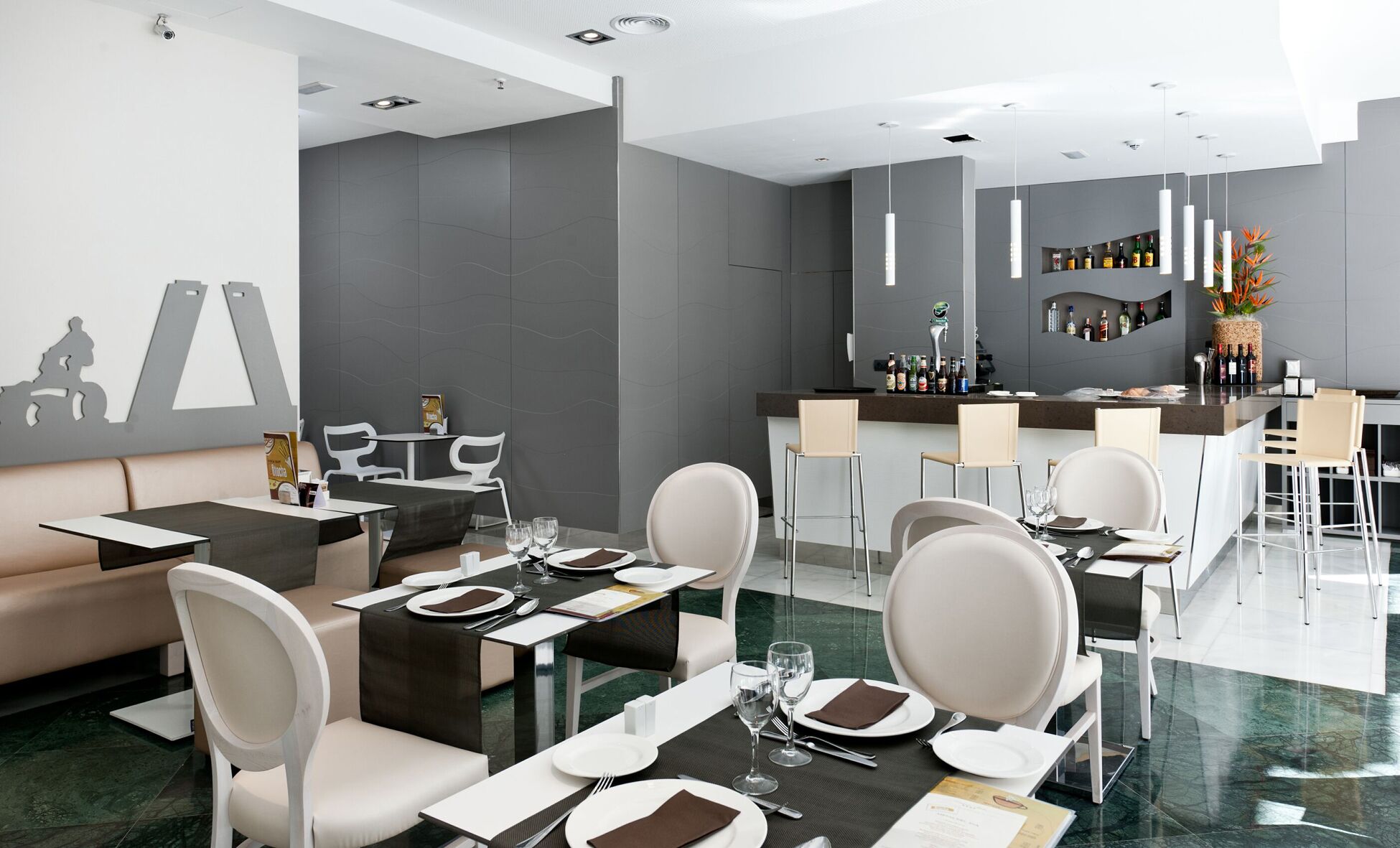 Restaurante moderno com área de bar, cadeiras brancas e design limpo e minimalista.