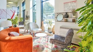 Um lobby moderno com assentos, janelas amplas e plantas em interior.