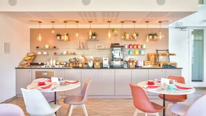 Cozinha moderna com ilha central, iluminação embutida e máquina de café.